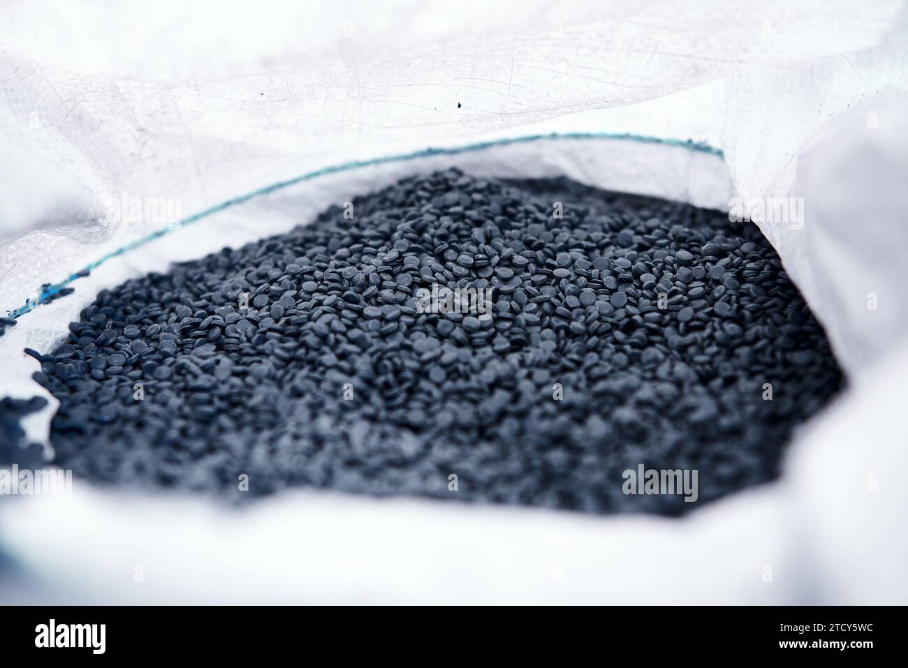 Black granules made of recycled waste plastic in open sack Stock Photo ...