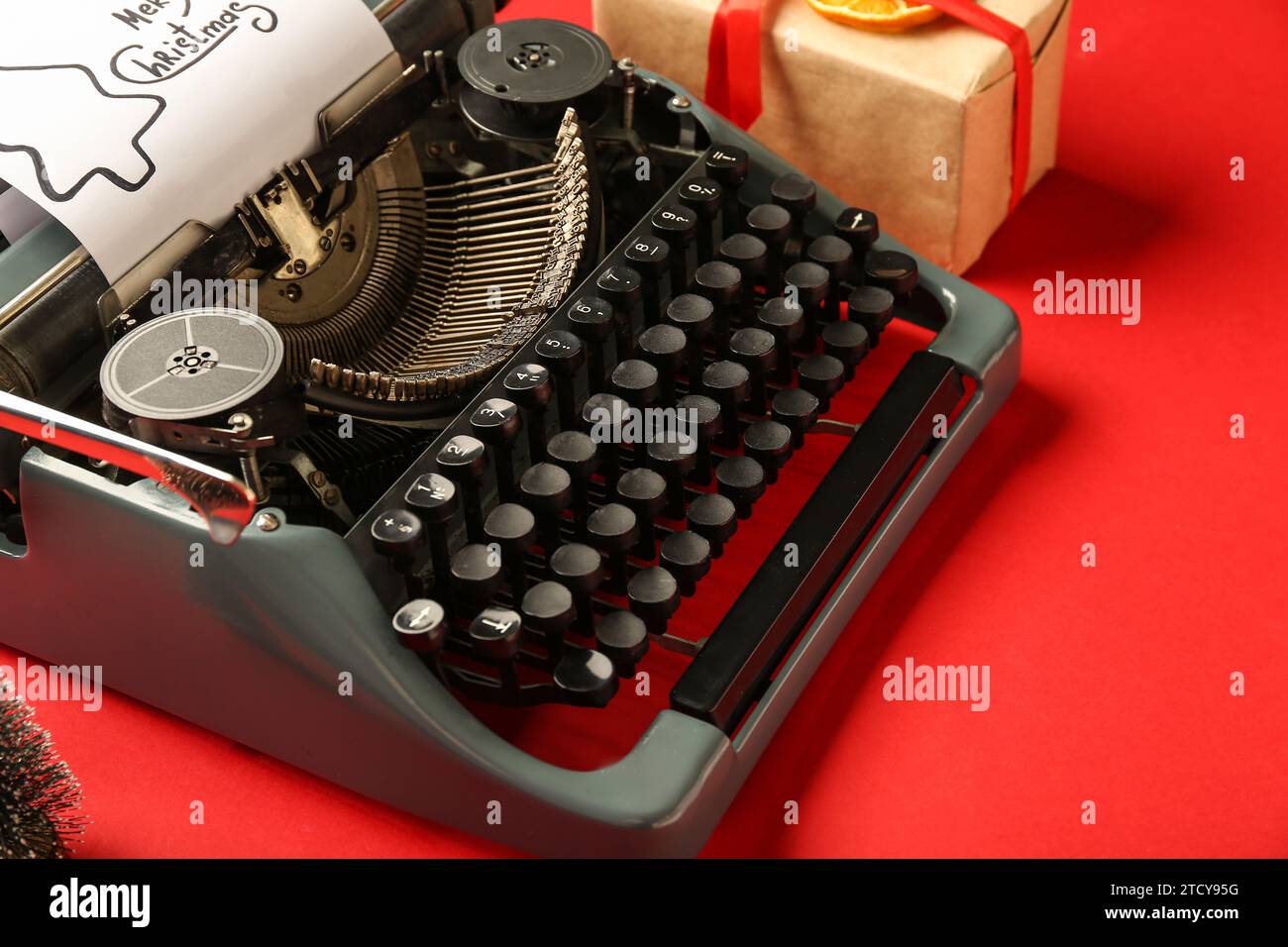 Paper sheet with text MERRY CHRISTMAS, vintage typewriter and decor on ...