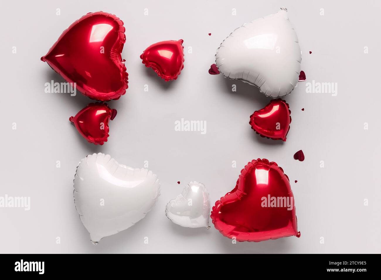 Frame made of heart shaped air balloons and confetti on grey background ...