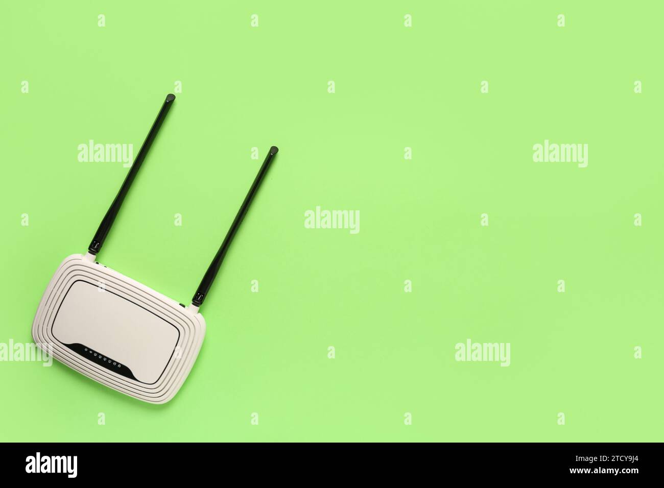 Modern wi-fi router on green background Stock Photo - Alamy