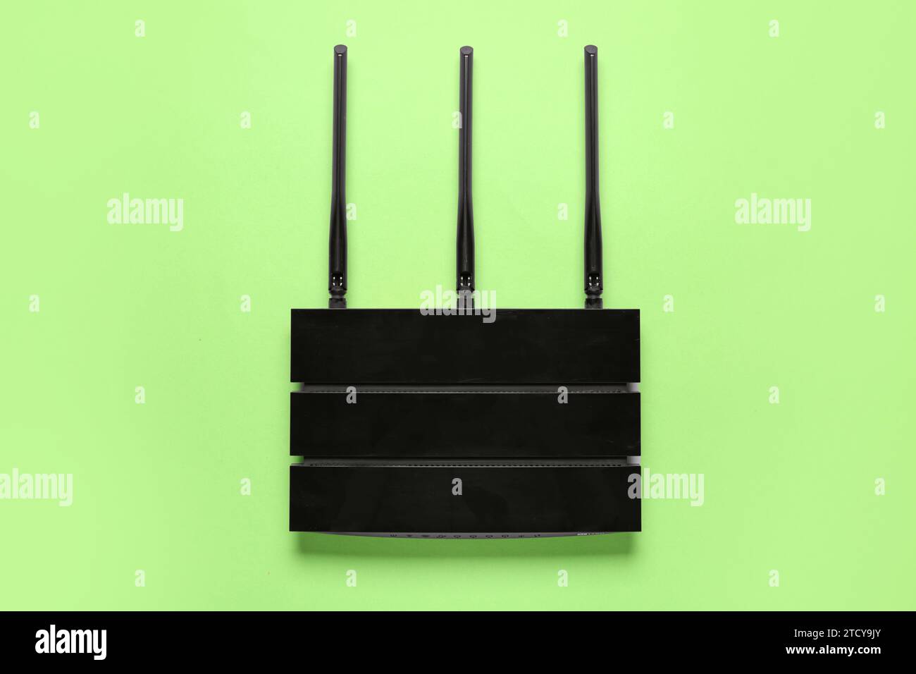 Modern wi-fi router on green background Stock Photo - Alamy