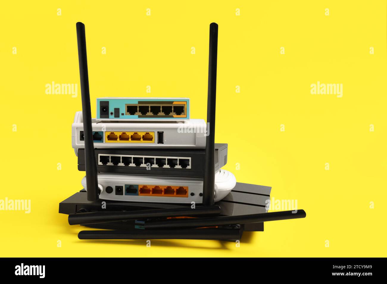 Modern wi-fi routers on yellow background Stock Photo - Alamy