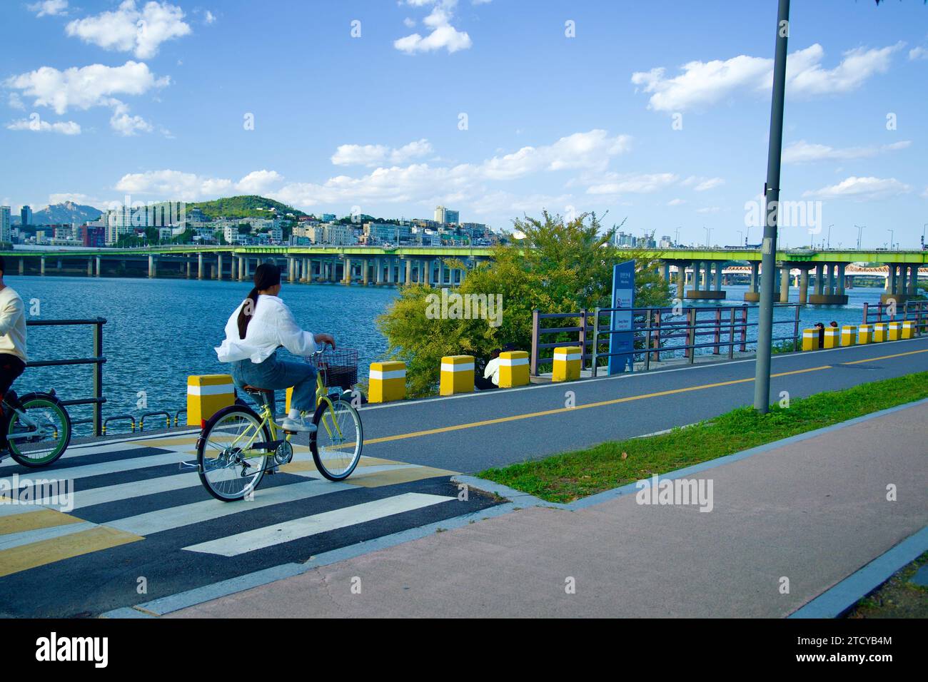 Seoul, South Korea - October 1, 2023: A cyclist cruises down the riverside bike path in Jamwon ...