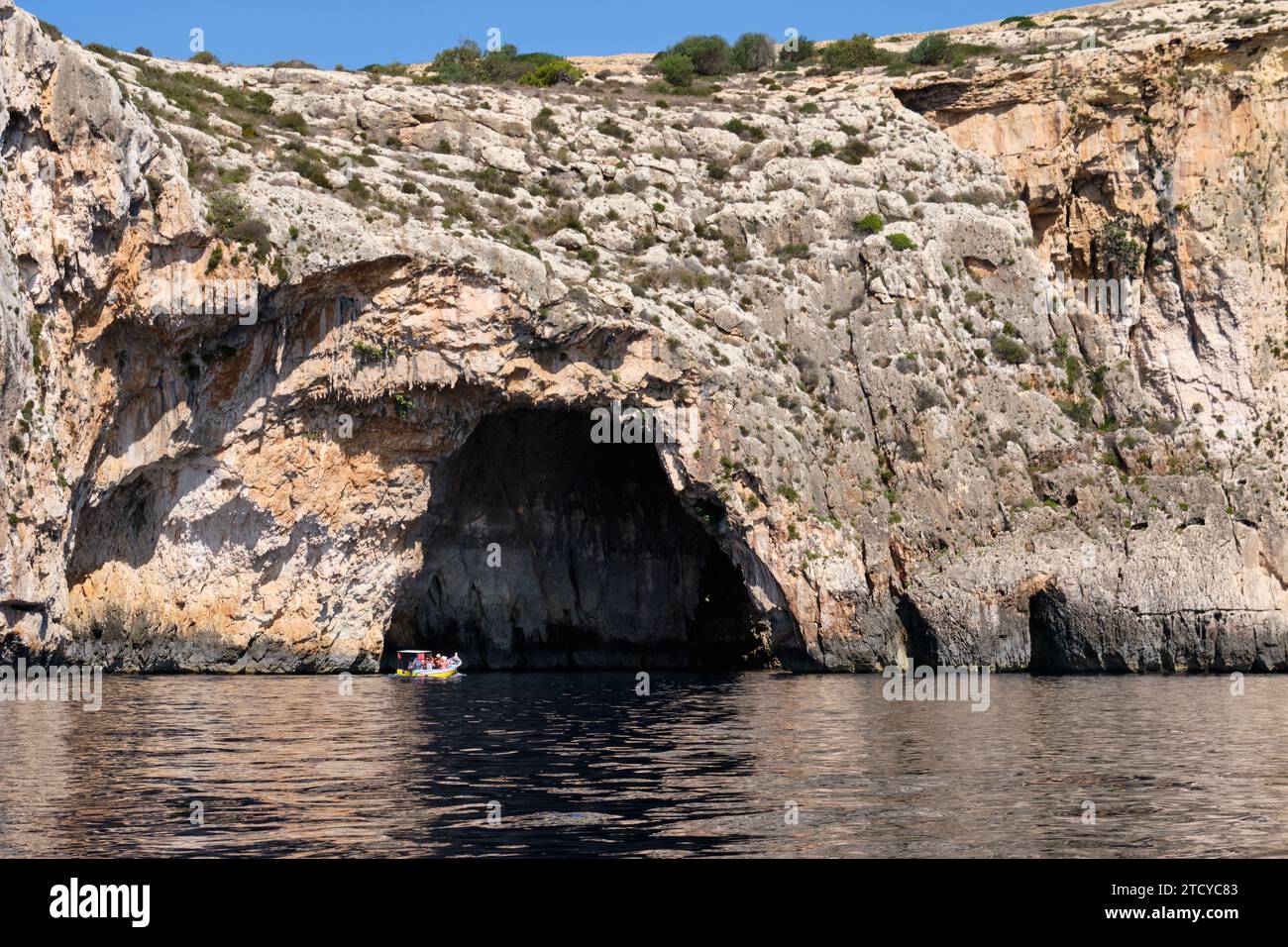 A tourist boat enters a cave at the Blue Grotto - Qrendi, Malta Stock ...