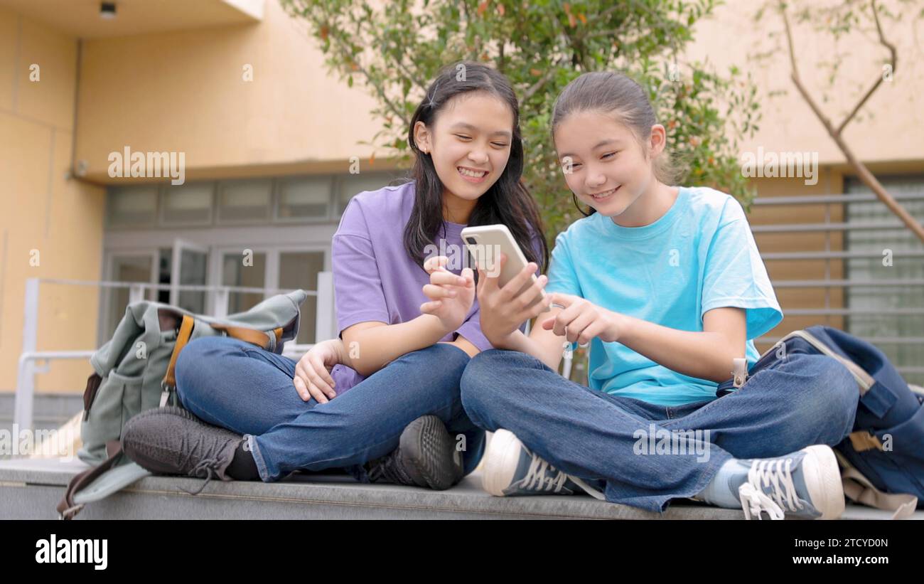 Happy Asian student girls using smart phone in school Stock Photo - Alamy