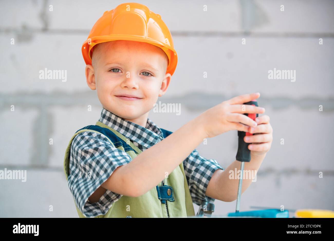 Child in building helmet, hard hat. Child dressed as a workman builder ...