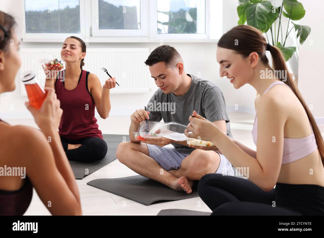 Group of people eating healthy food after yoga class indoors Stock ...
