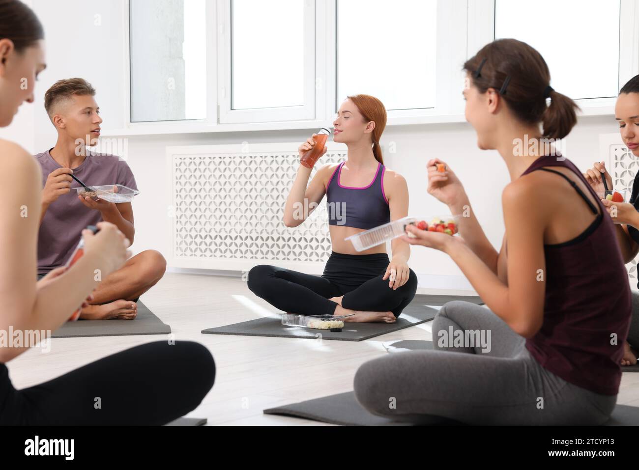 Group of people eating healthy food after yoga class indoors Stock ...