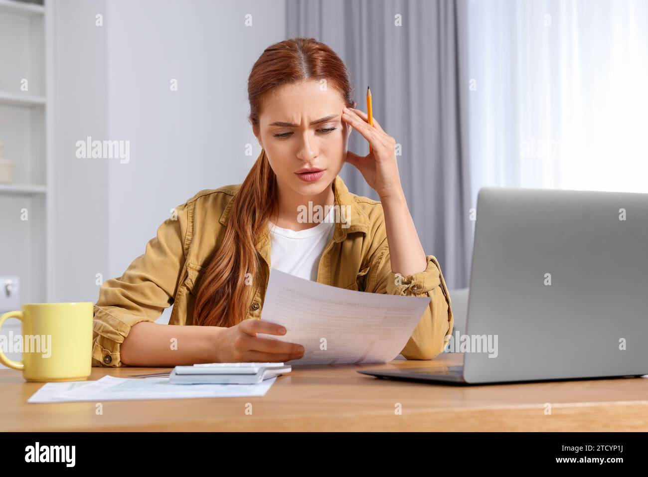 Woman doing taxes at table in room Stock Photo - Alamy