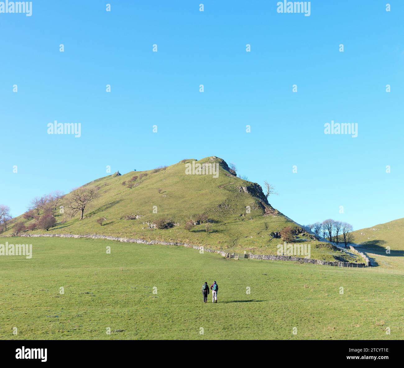 A couple of ramblers walk on open ground towards Parkhouse Hill, Peak ...