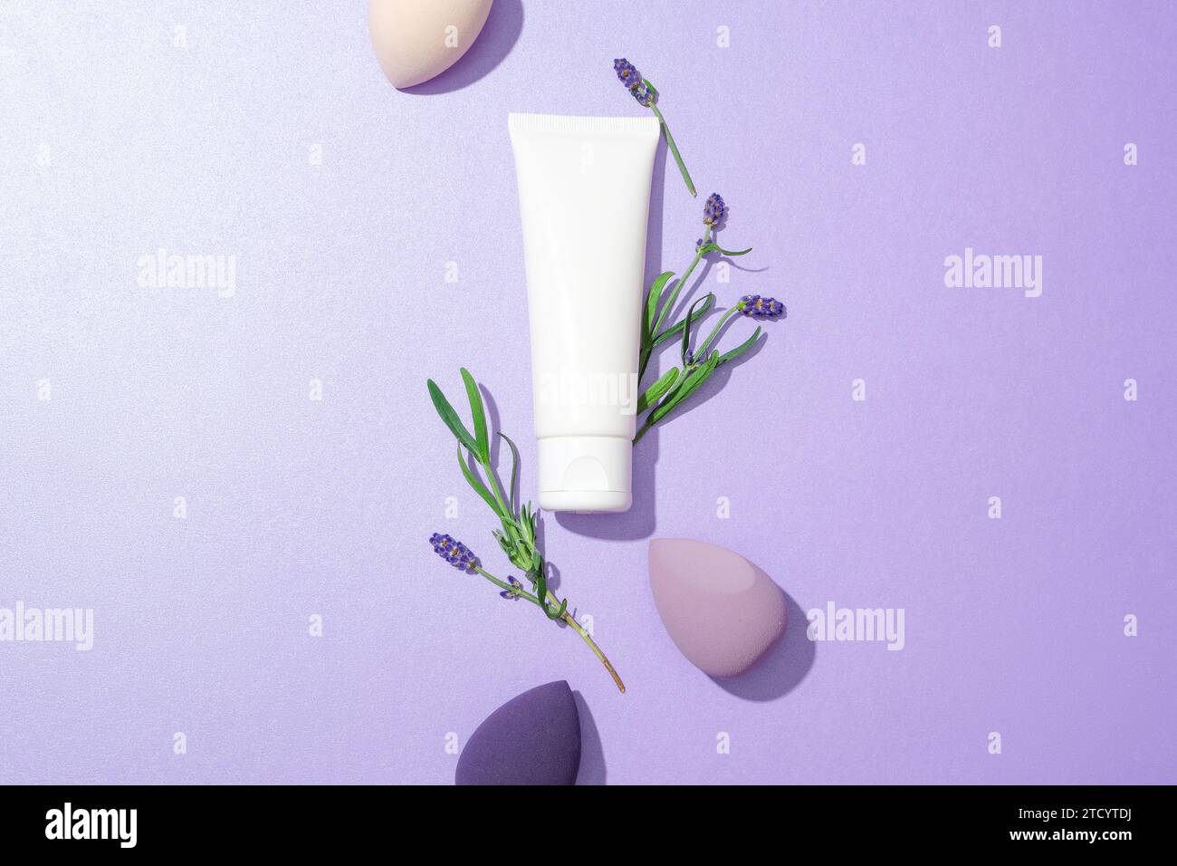 Top view of a white tube displayed on a purple background, surrounded ...