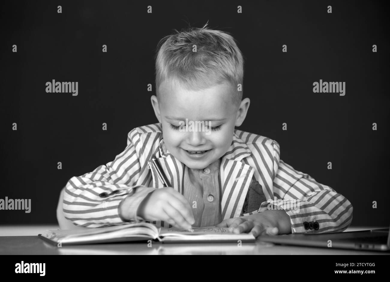 Kid writing in class. Portrait of funny pupil of primary school study ...