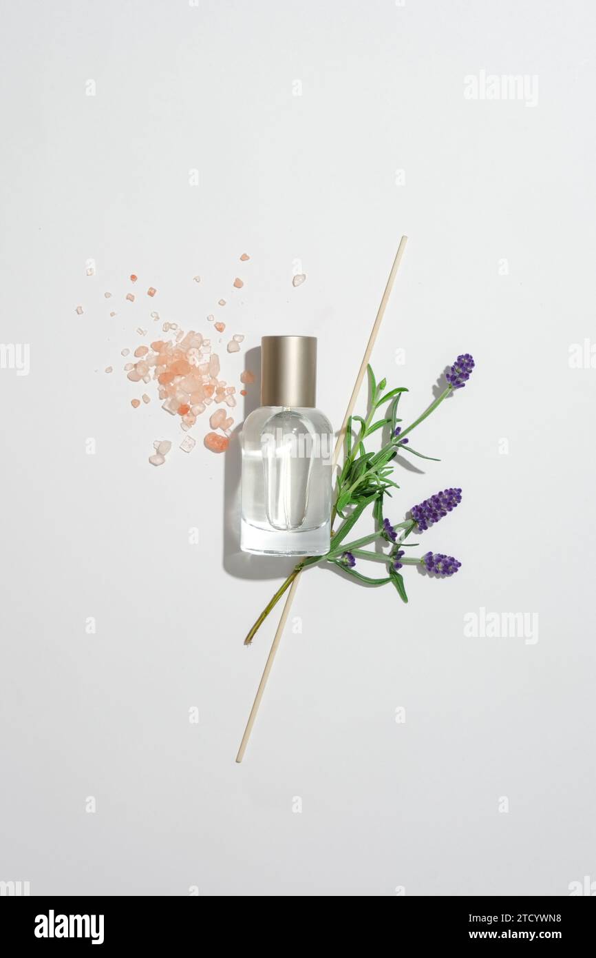 Top view of a transparent perfume bottle, pink salt and fresh lavender ...
