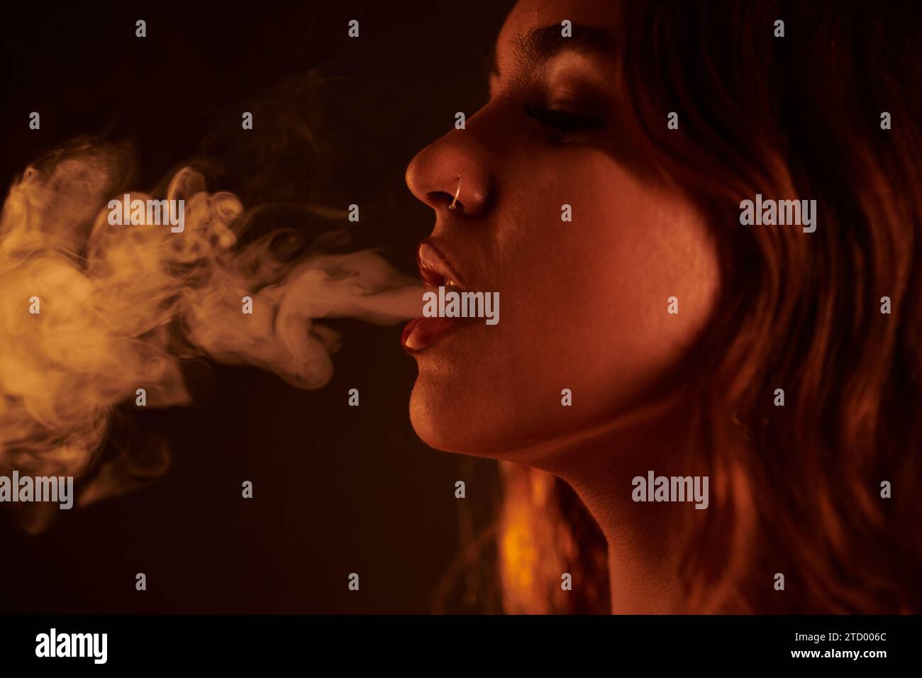 Young woman with piercing exhaling smoke of hookah Stock Photo - Alamy