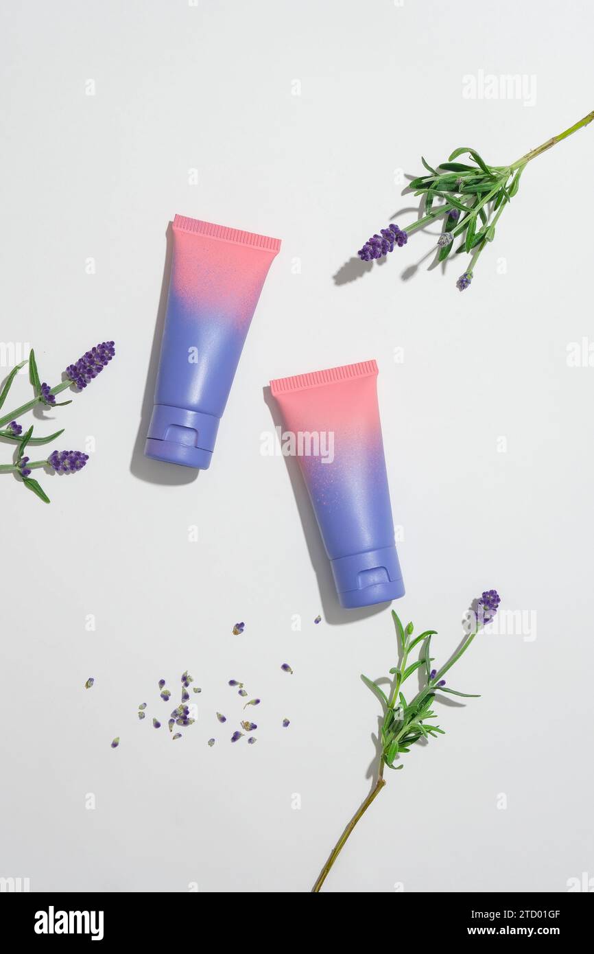 On a white background there are two tubes of sunscreen and fresh ...