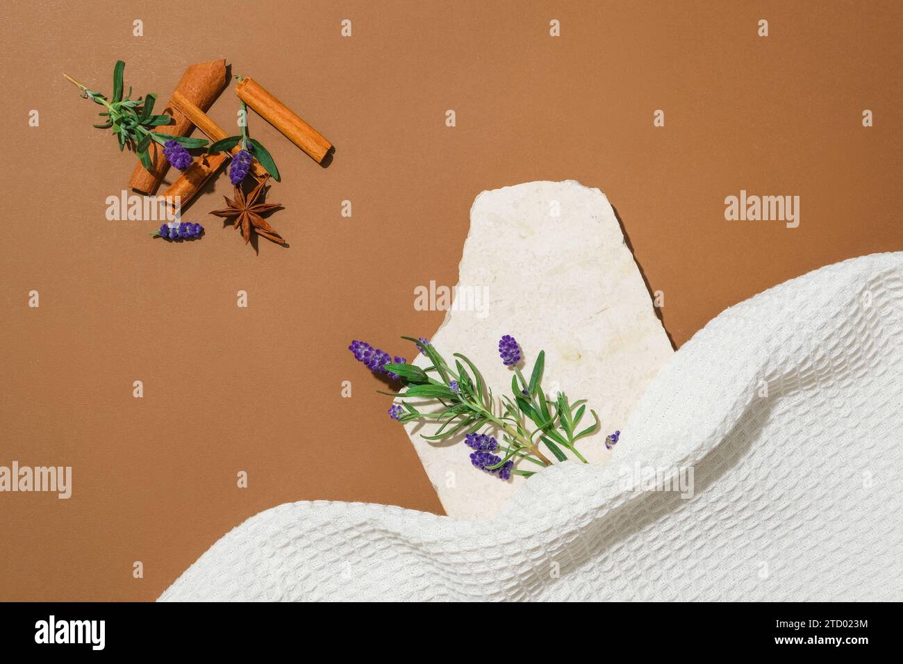 An unlabeled perfume bottle and a glass rod are placed on a stone ...