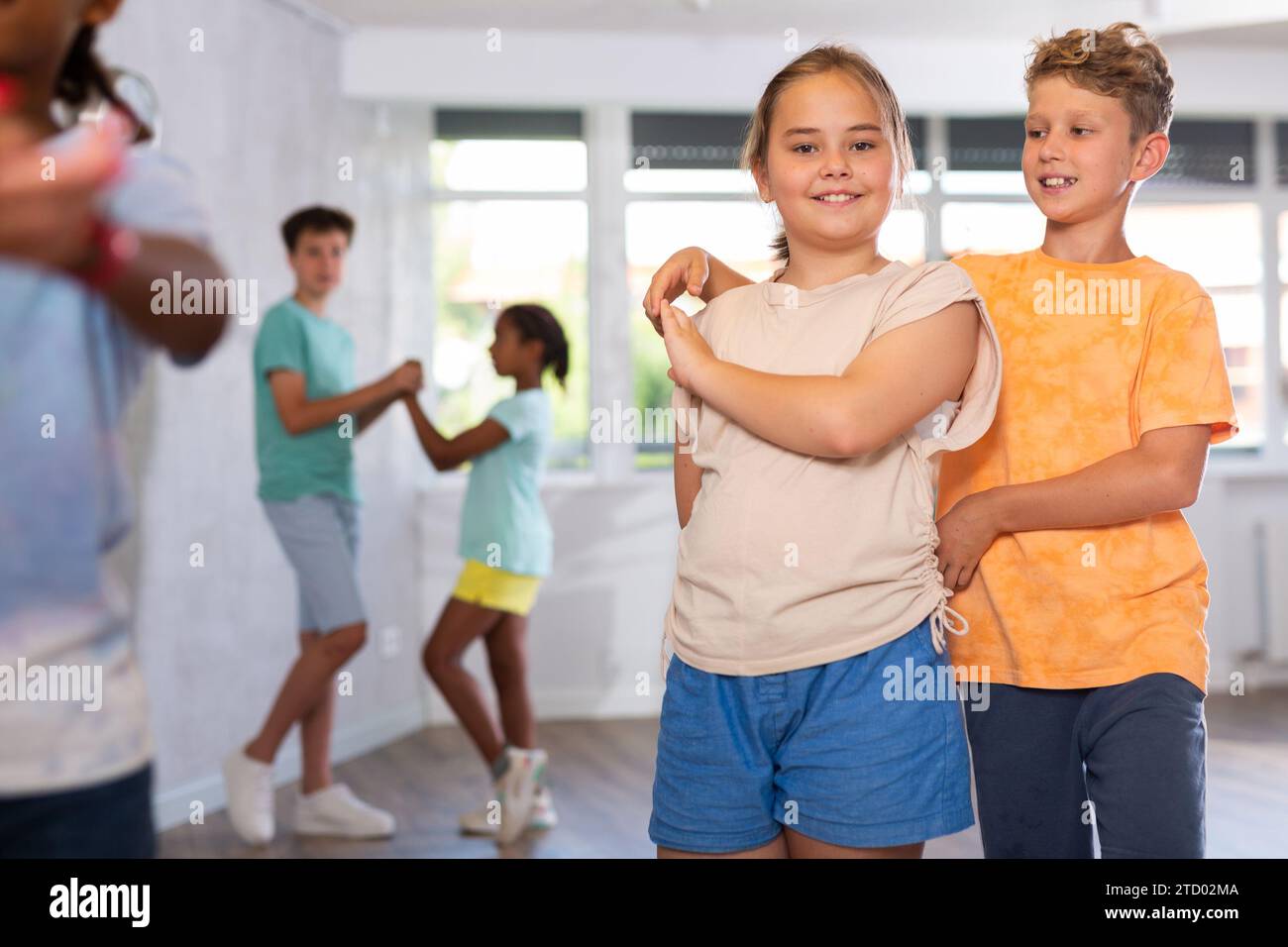 Tween girl and boy dancing waltz as couple in choreographic studio ...