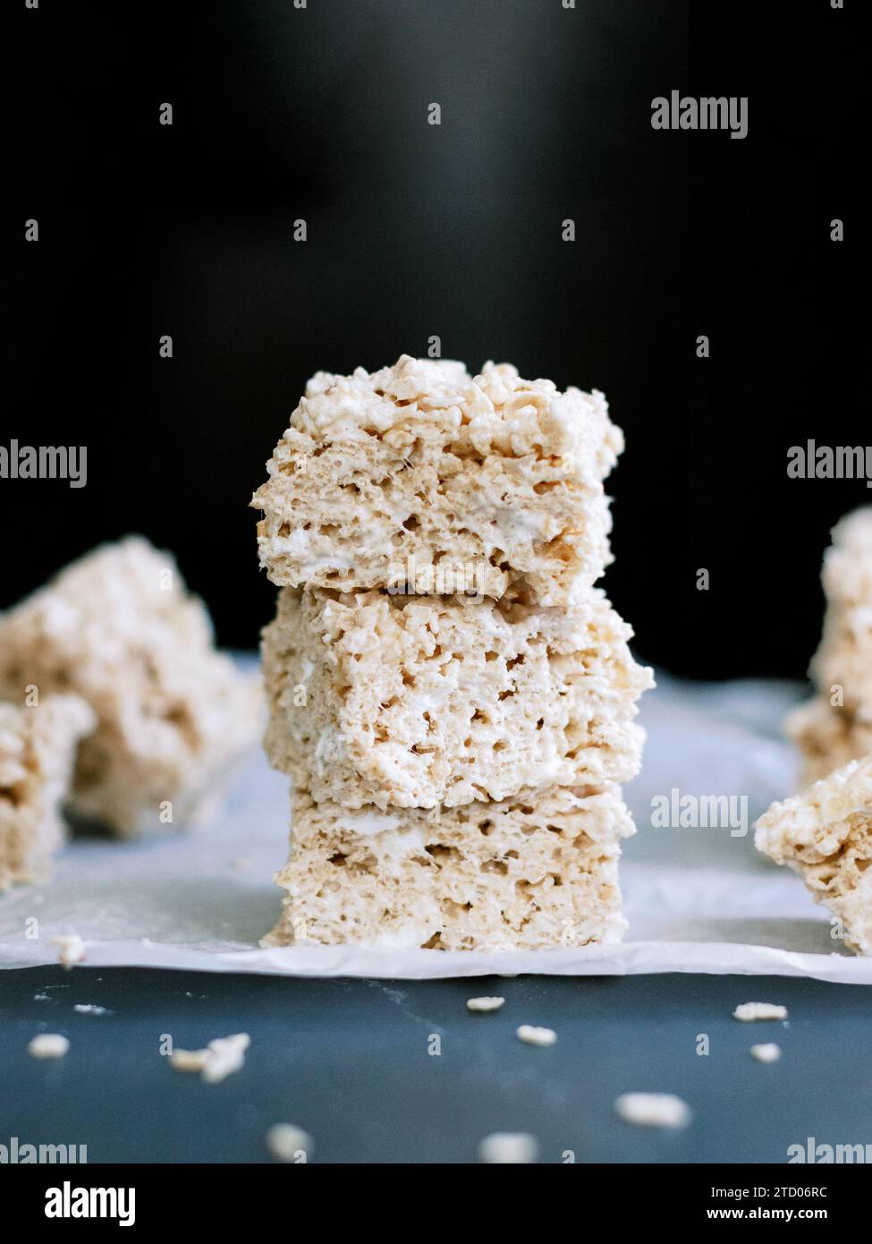 rice krispie treat stacked on parchment and blue background Stock Photo ...