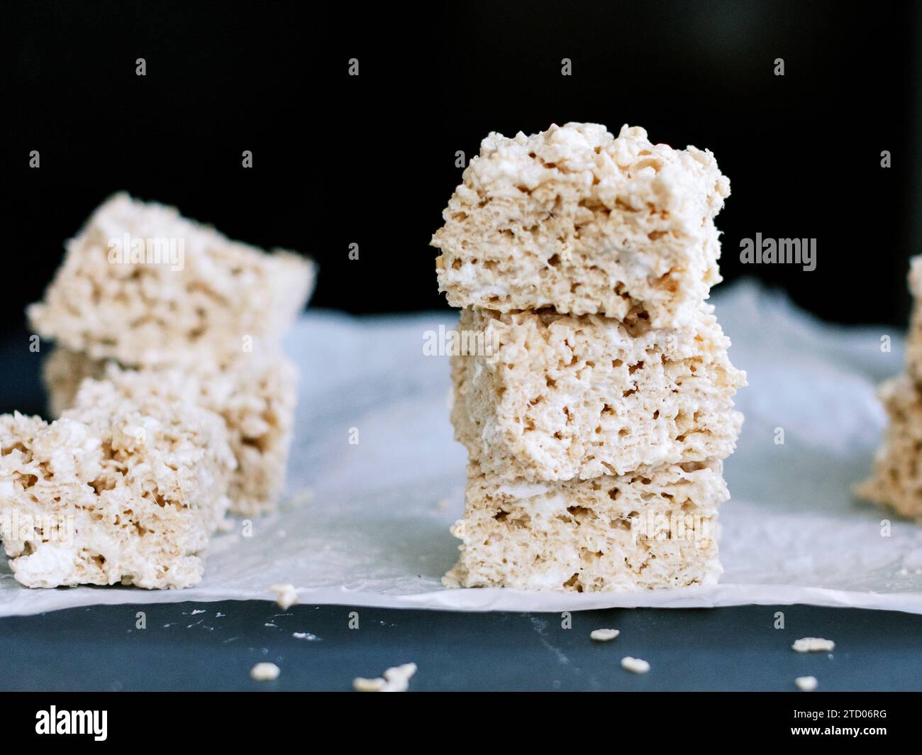 rice krispie treat stacked on parchment and blue background Stock Photo ...