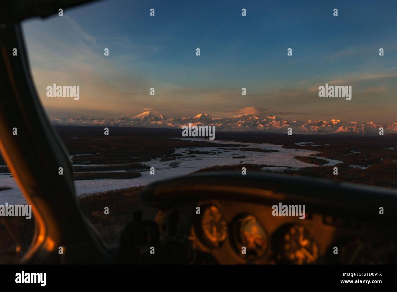 Sun sets on the Alaska range as seen through an airplane window Stock ...