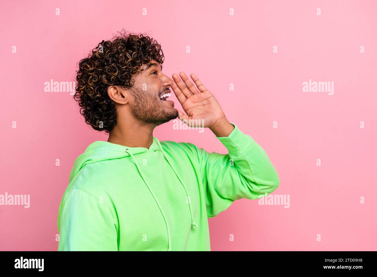 Side photo of funny young guy brown curly hair wearing green hoodie ...