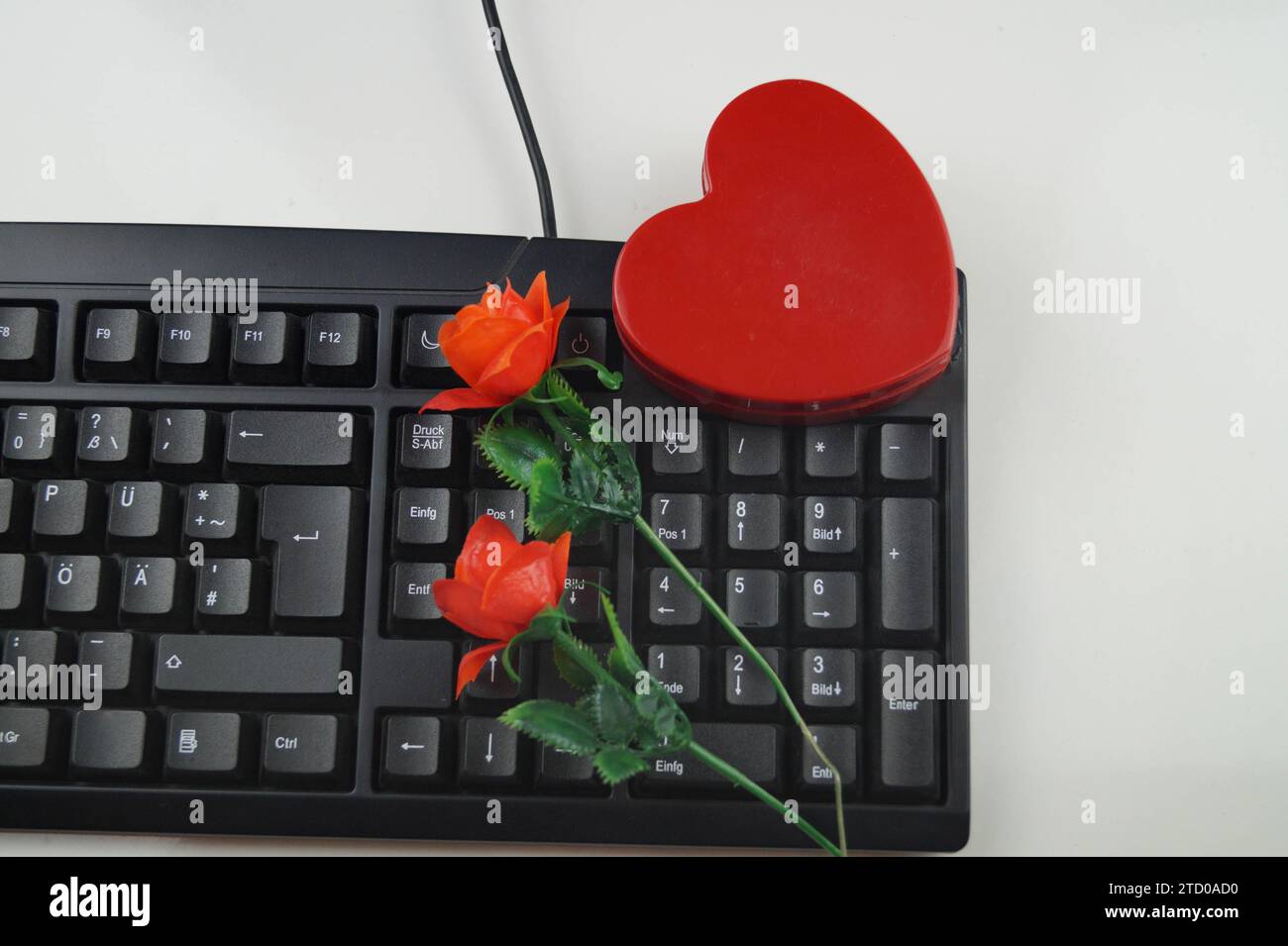 red heart and red roses with computer keyboard, symbolic image of love ...