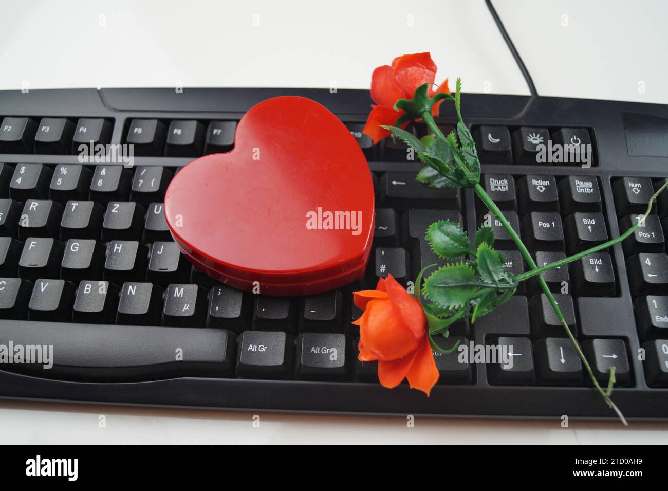 red heart and red roses with computer keyboard, symbolic image of love ...