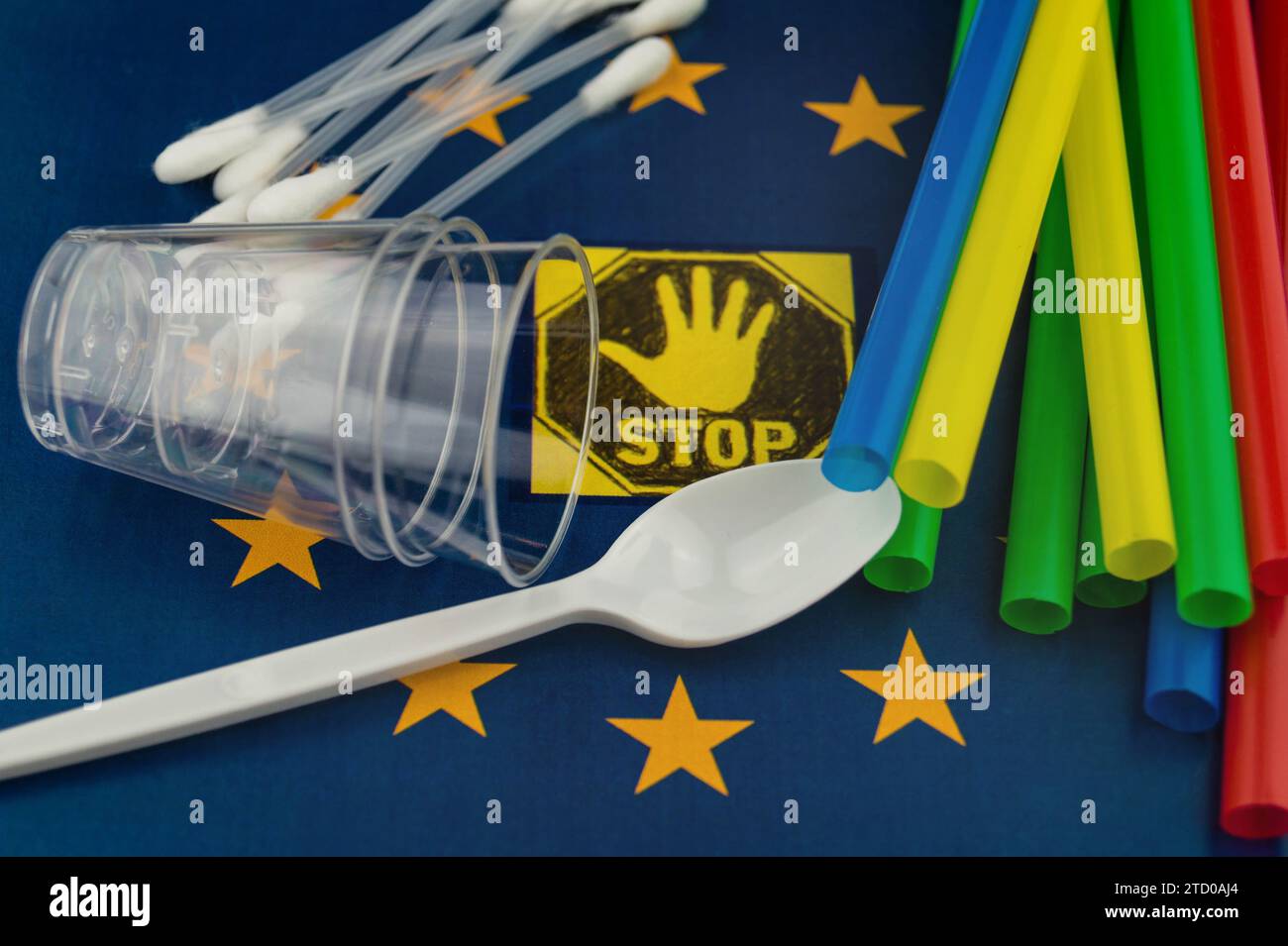 Plastic straws, cups, cutlery and cotton buds on European flag with ...