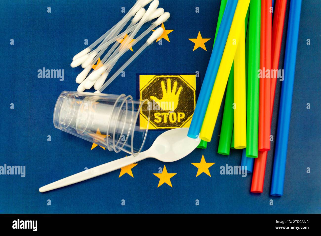 Plastic straws, cups, cutlery and cotton buds on European flag with ...