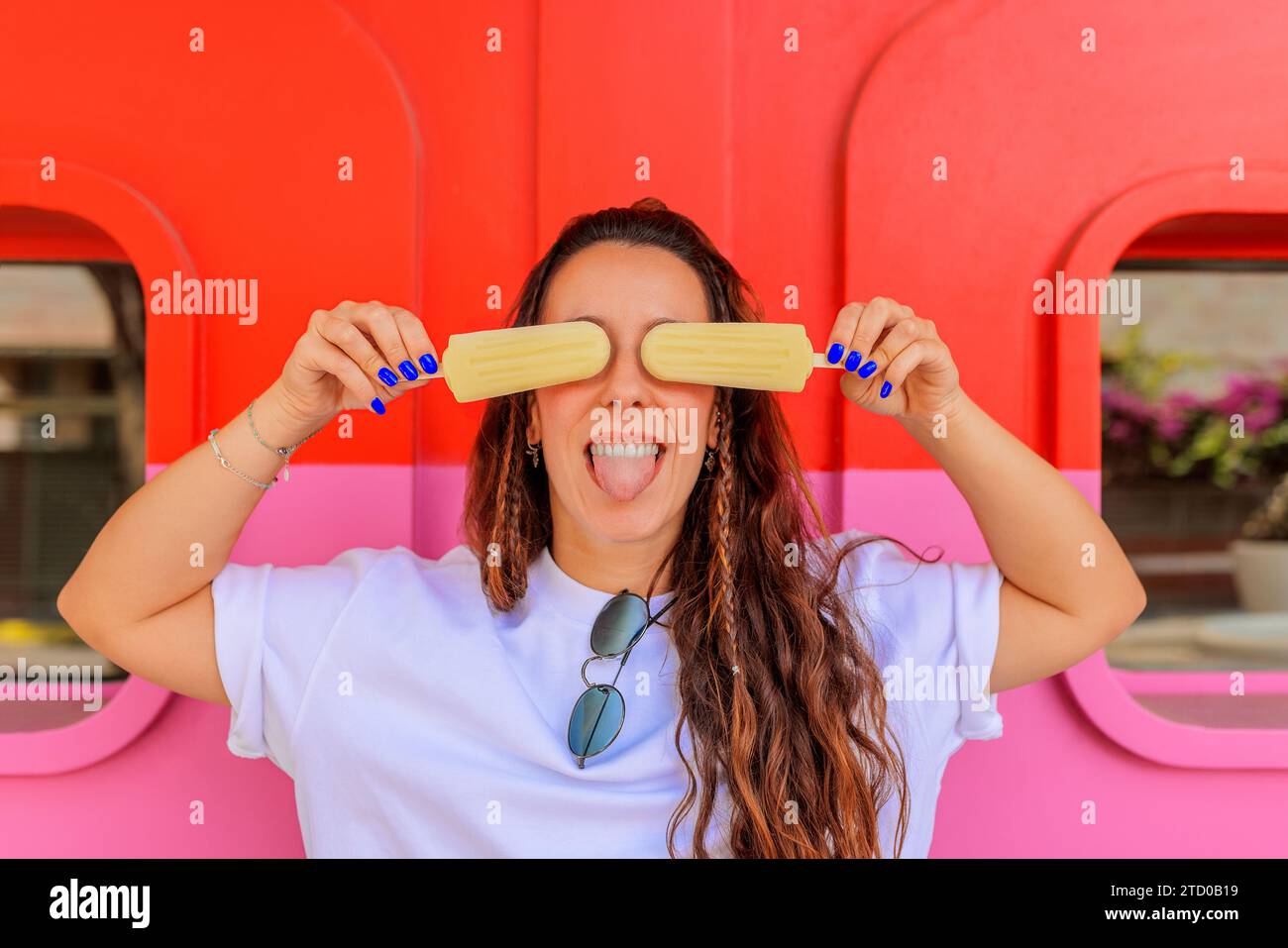 Playful Caucasian young brunette woman covering eyes with ice cream ...