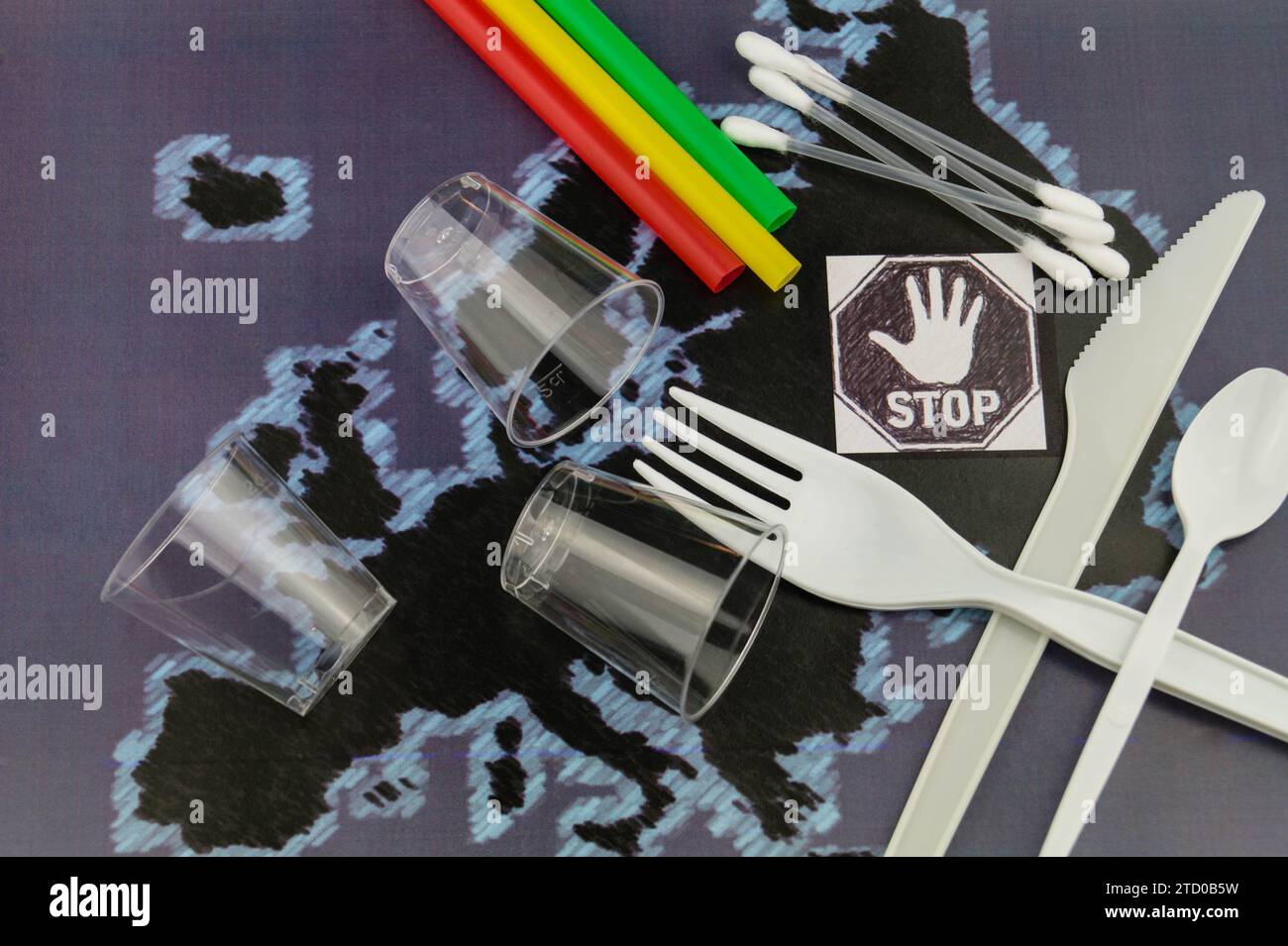Plastic cutlery, cups and straws on a map of Europe with stop sign, ban ...