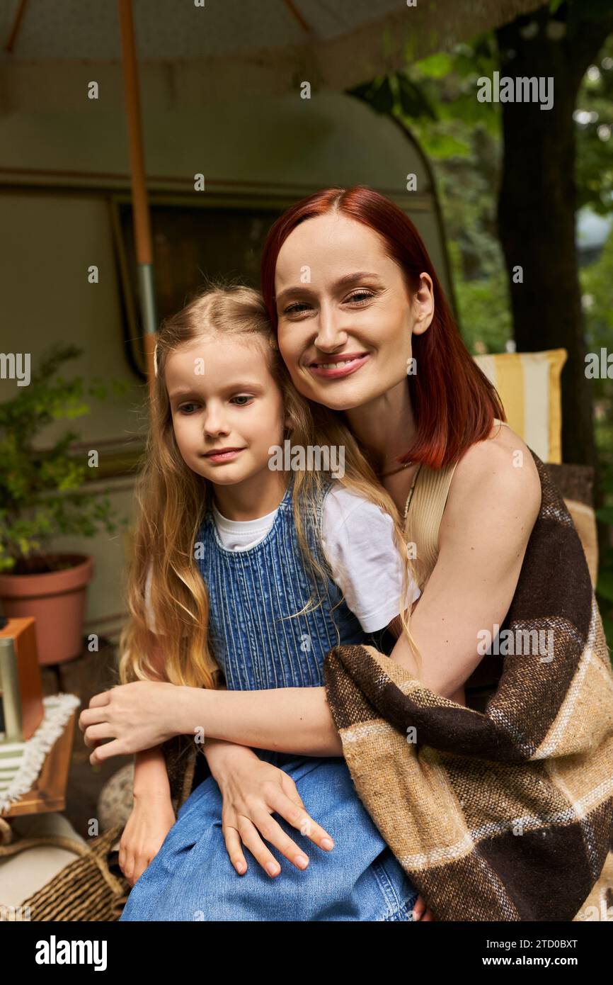 happy woman with adorable daughter looking at camera near modern ...