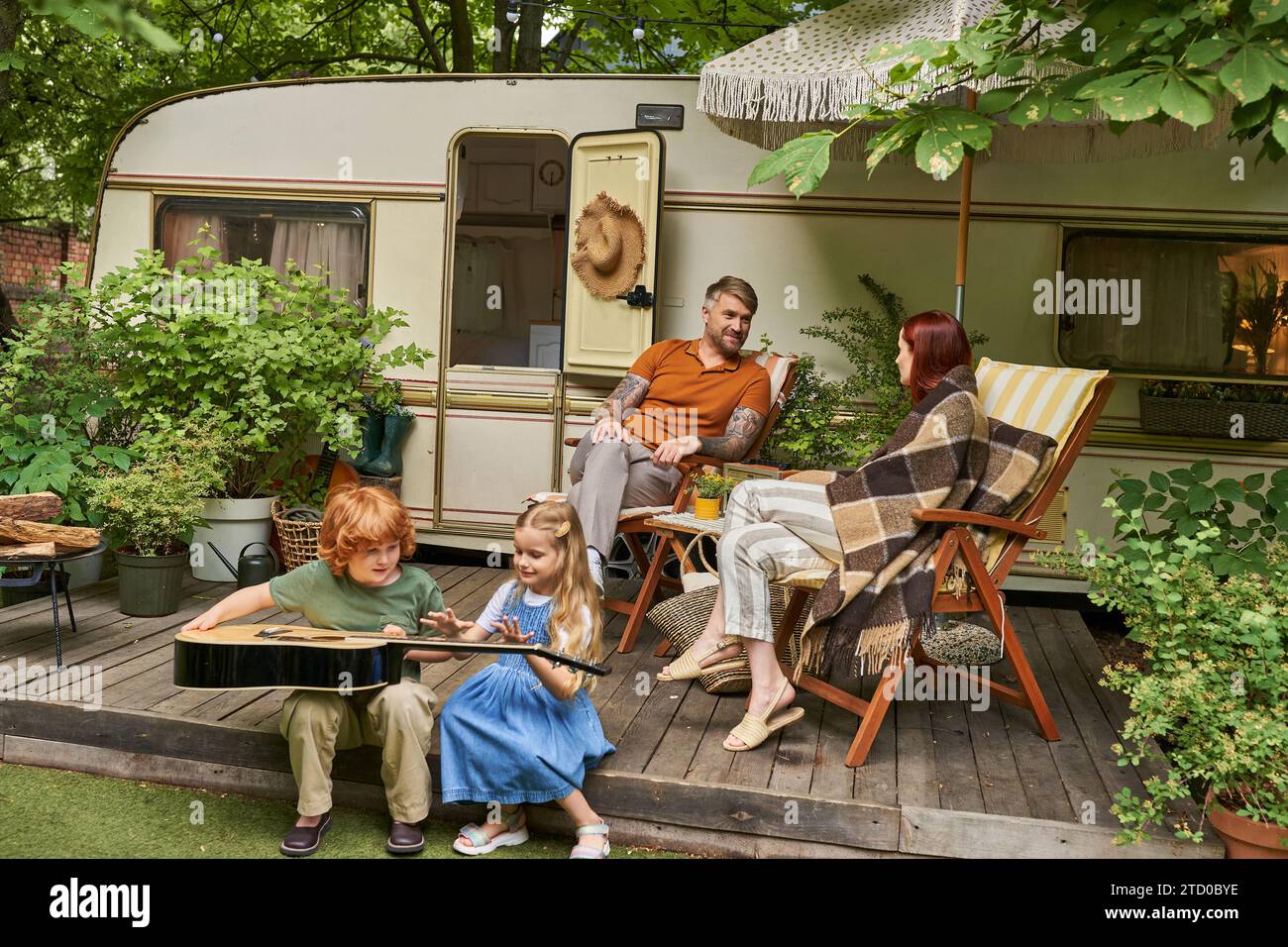 kids learning to play acoustic guitar while parents talking in deck ...
