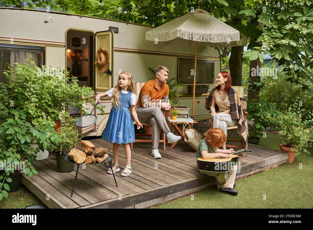 children playing badminton and acoustic guitar near parents sitting ...