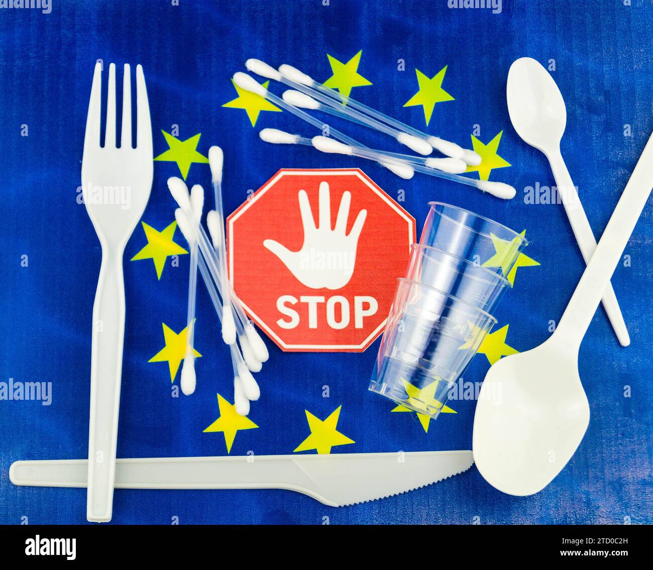 Plastic objects, cutlery, cups and cotton buds on European flag with ...