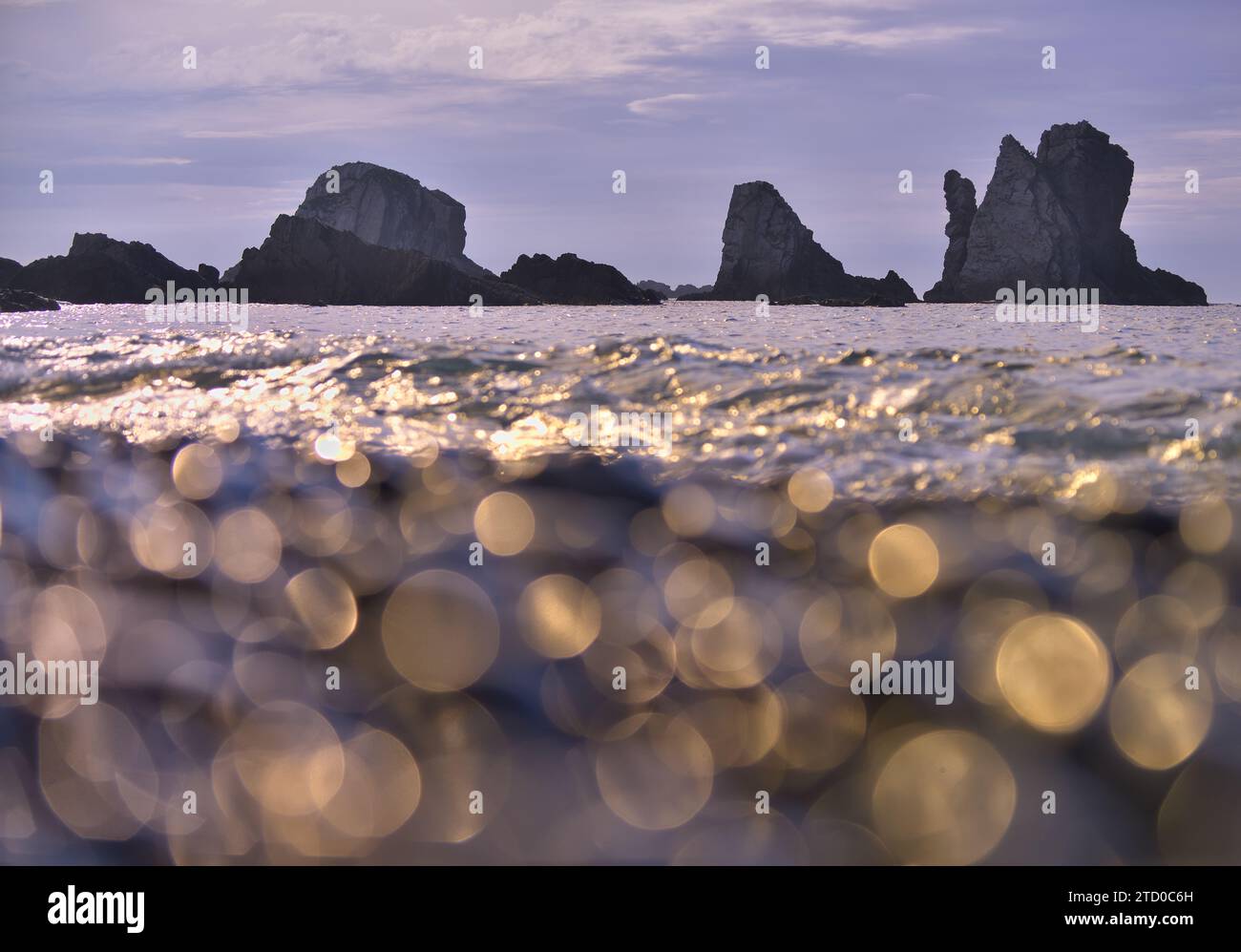 The image captures the serene beauty of glistening ocean waves at dusk ...