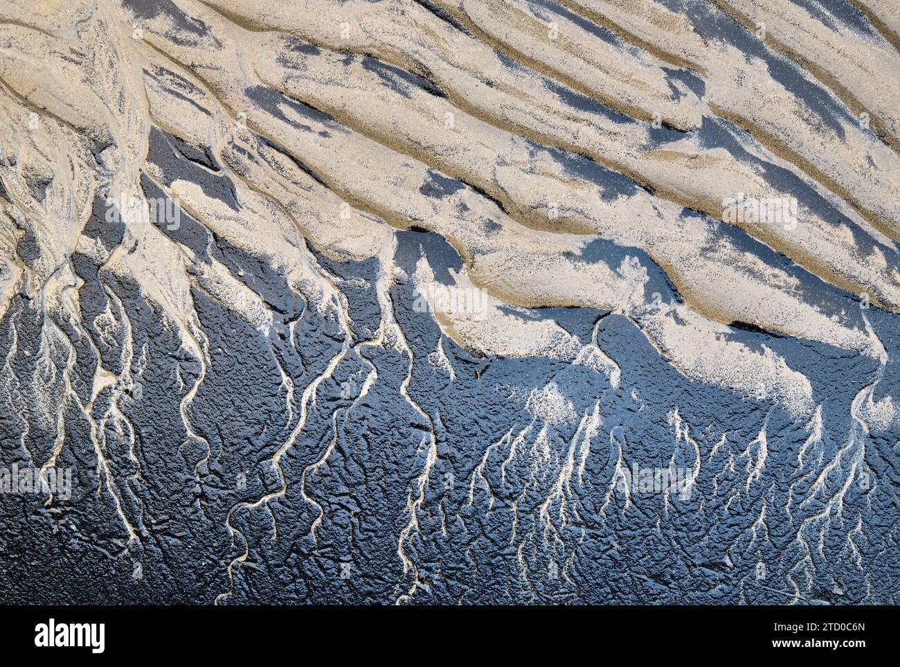 A captivating aerial view of natural patterns created by sand and water ...