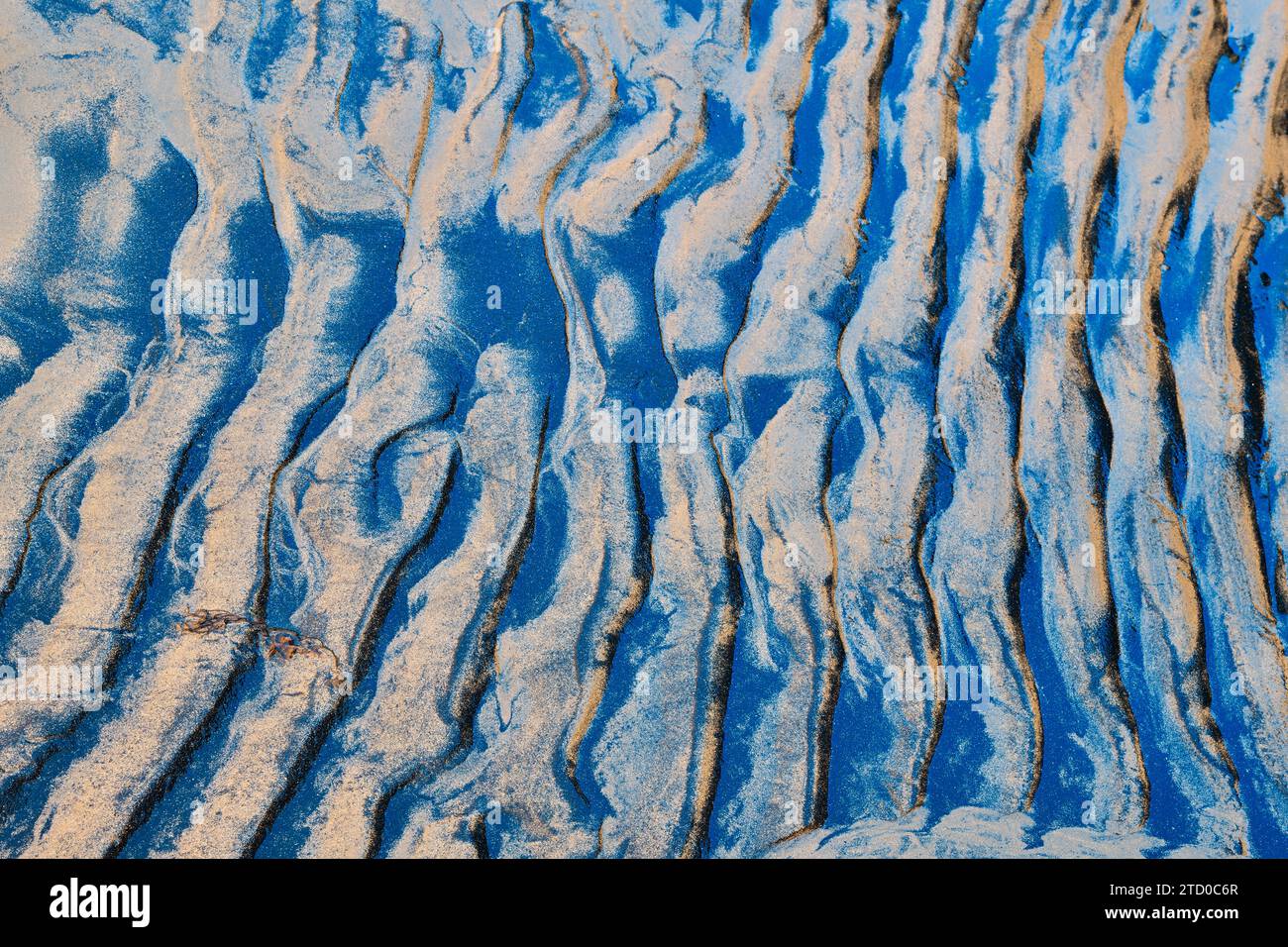 Abstract natural art of wavy sand patterns highlighted with deep blue ...