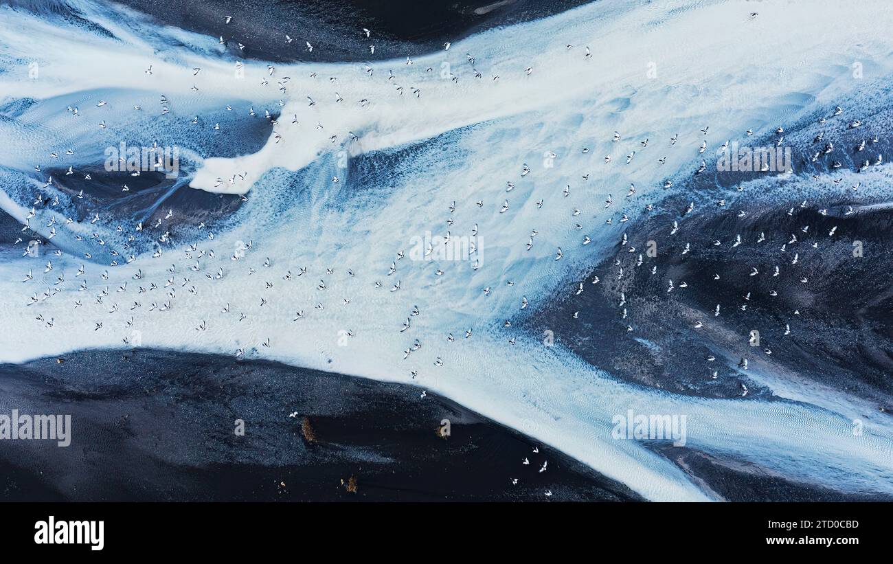 An aerial shot capturing the intricate patterns of a frozen river in ...