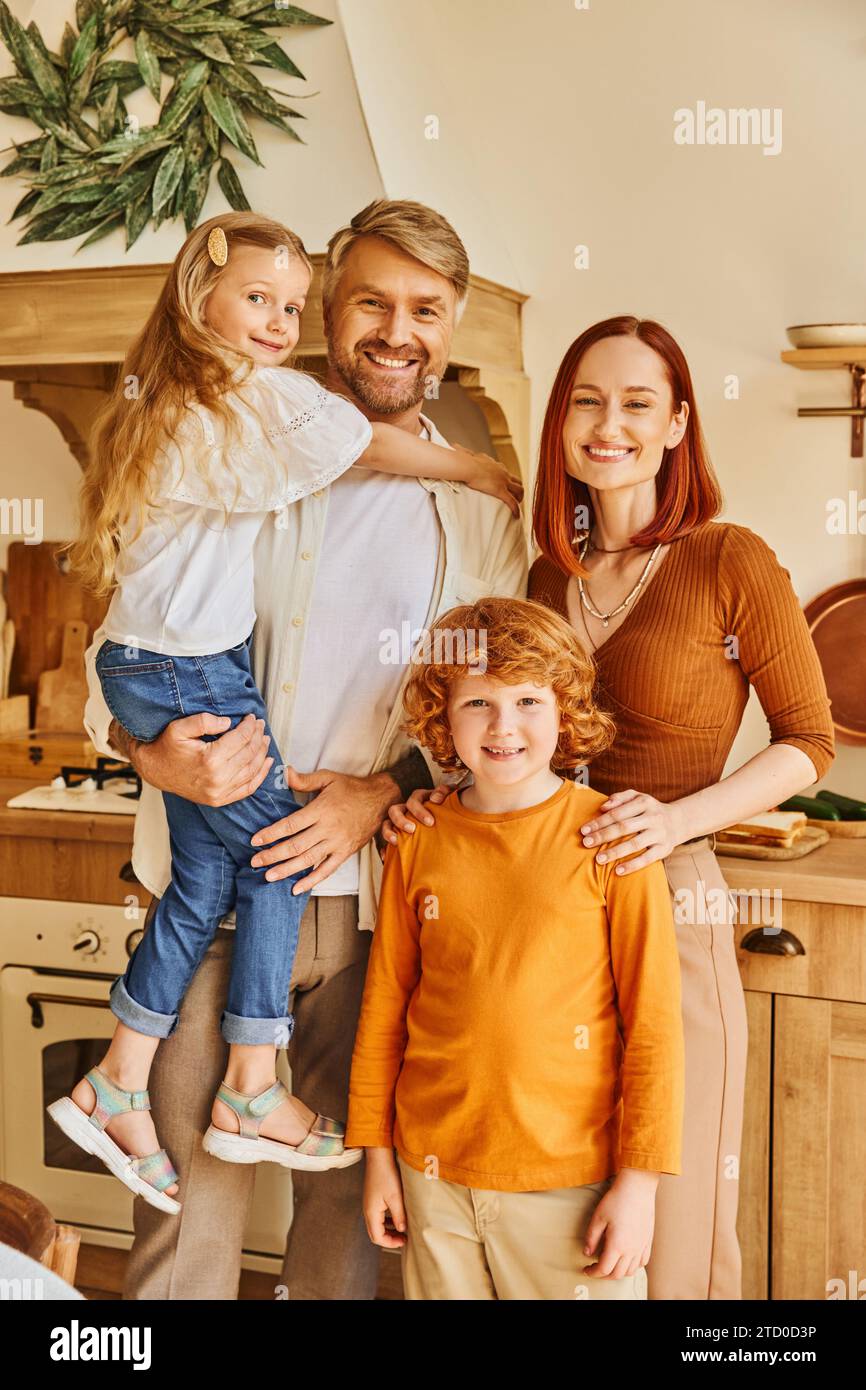 cheerful kids with smiling parents looking at camera in modern kitchen ...