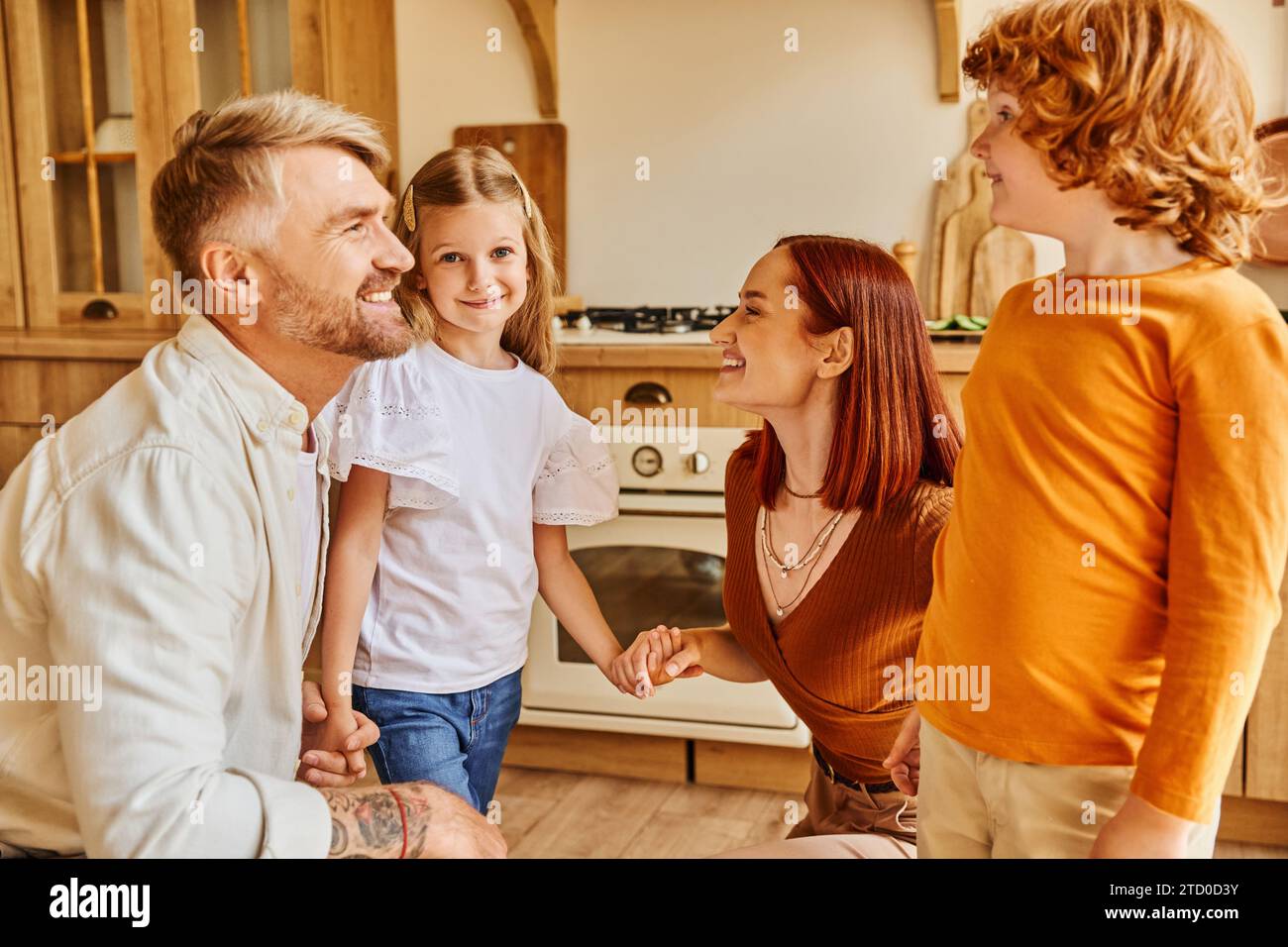 smiling parents with carefree kids holding hands while having fun in ...
