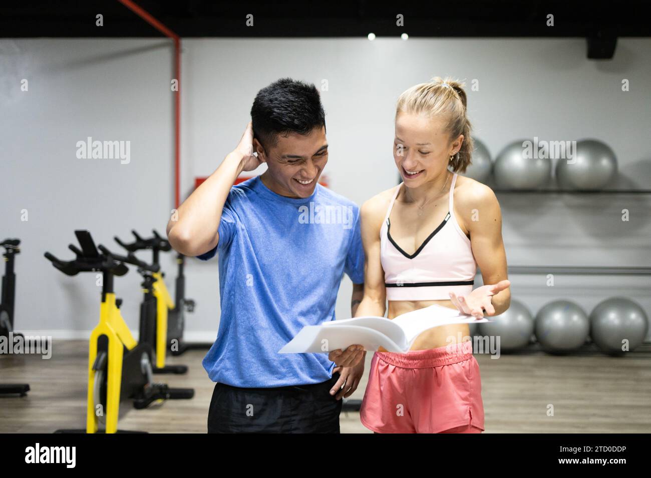 A young female client is happily discussing her new workout regimen ...