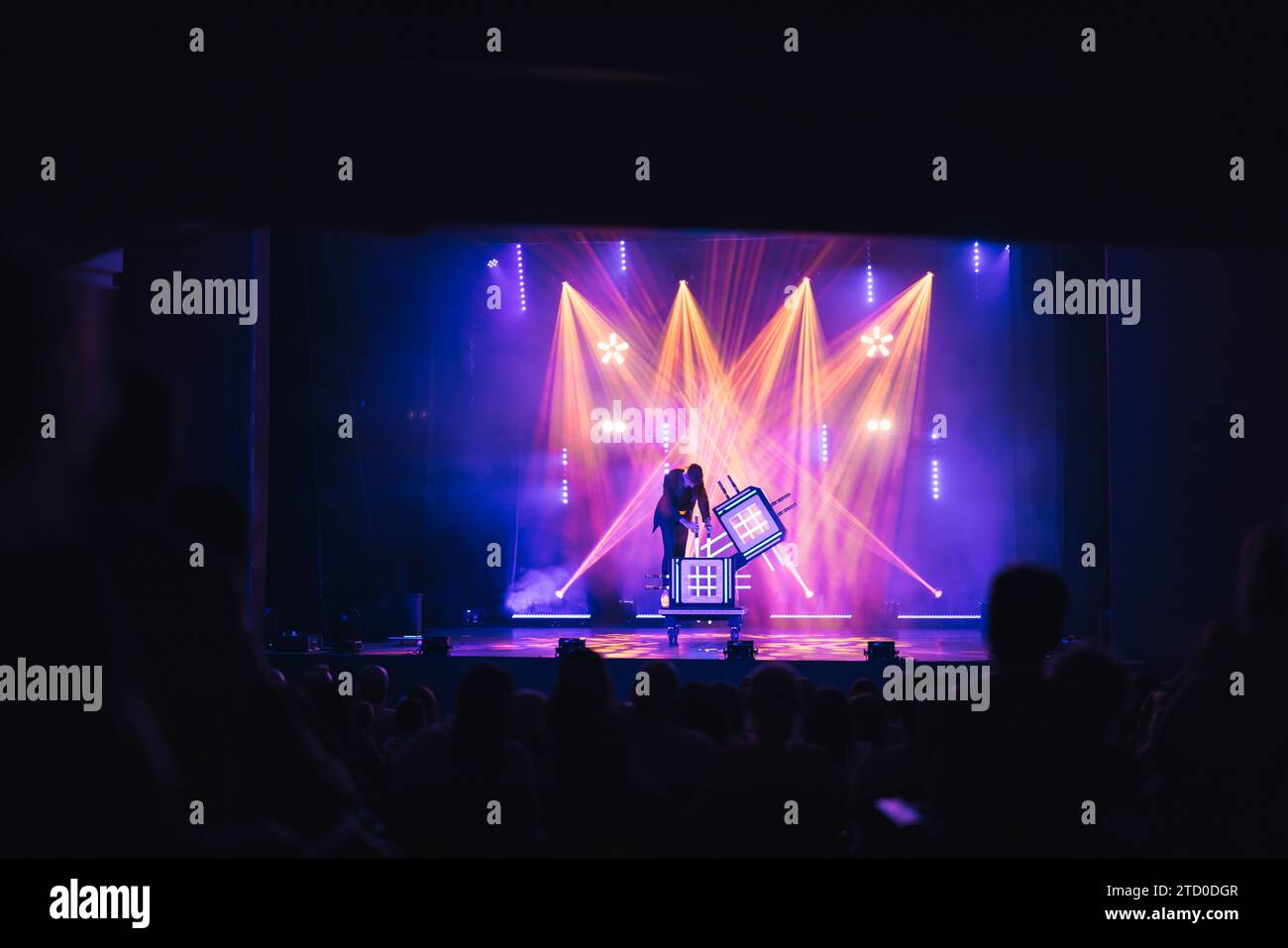 Professional male magician showing magic trick with glass boxes on ...