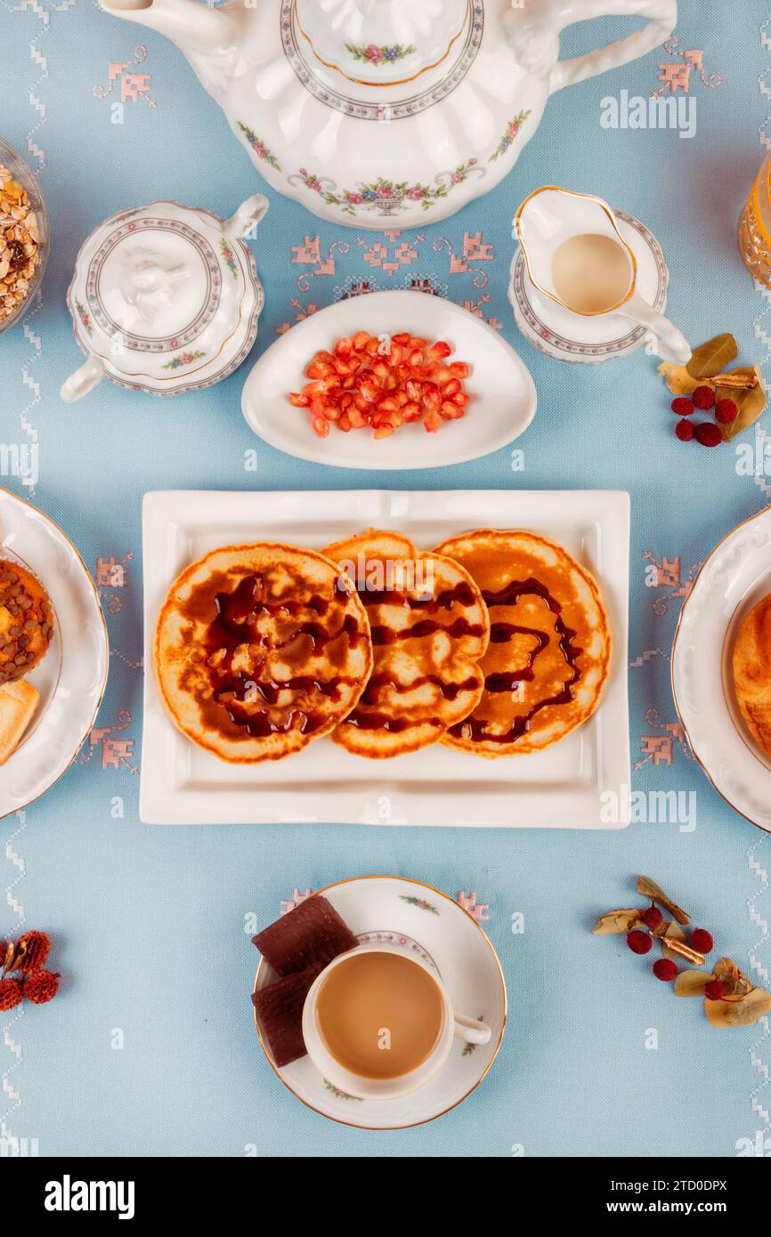 A top view of an afternoon tea arrangement with waffles, sweets, and a ...
