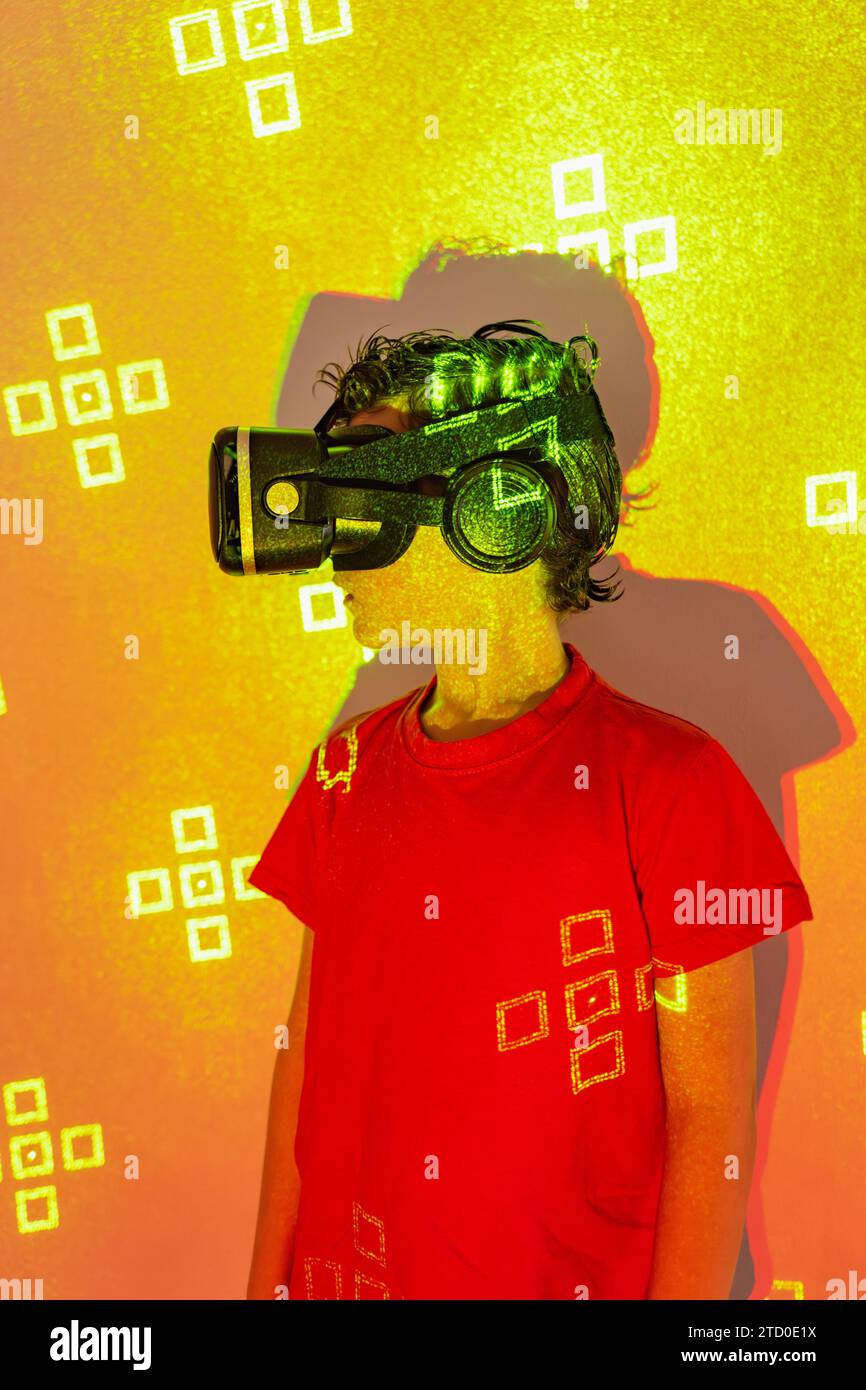 Boy in casual clothes and modern VR goggles experiencing virtual ...