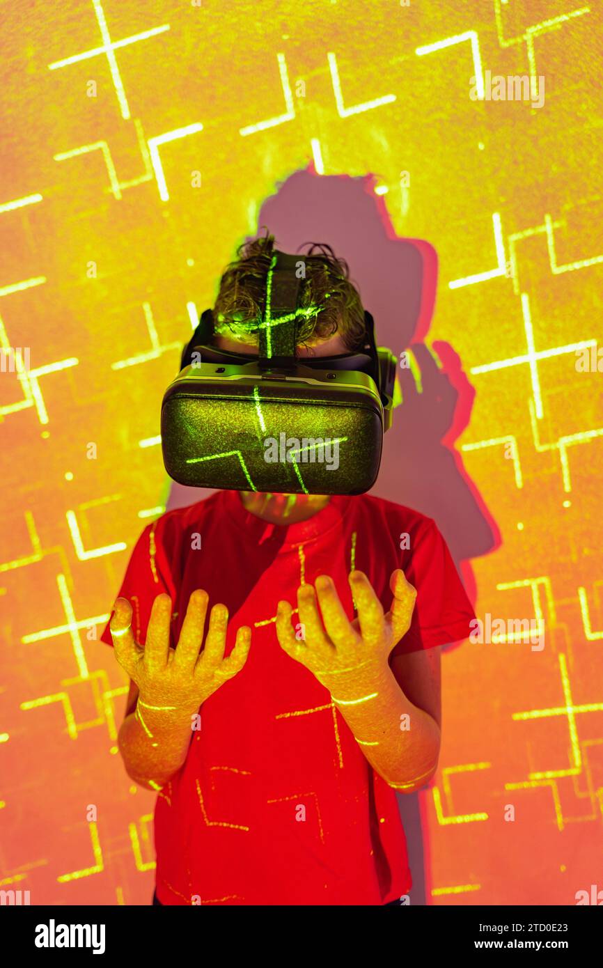 Boy in casual clothes and modern VR goggles experiencing virtual ...