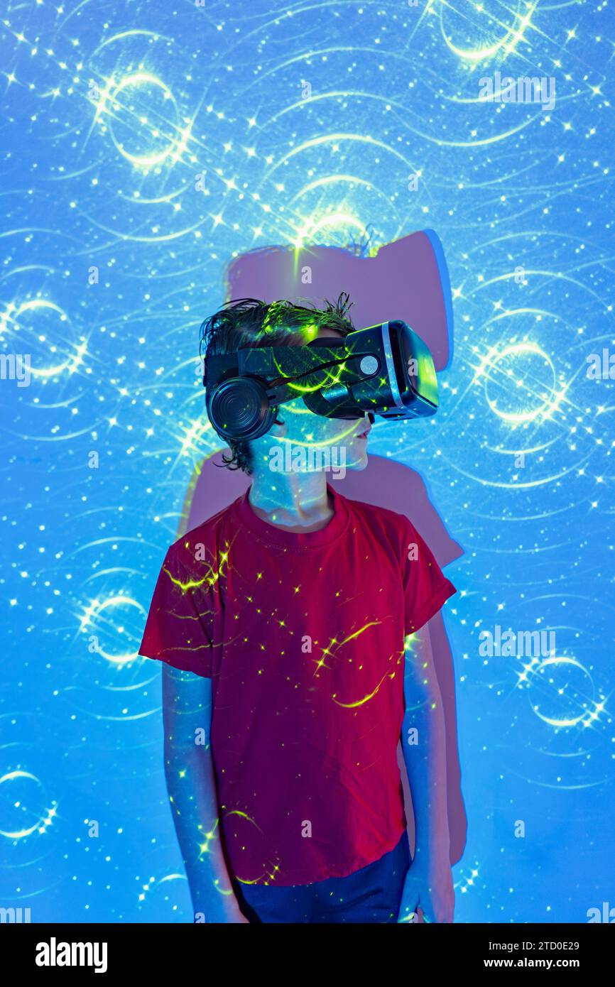 Boy in casual clothes and modern VR goggles experiencing virtual ...