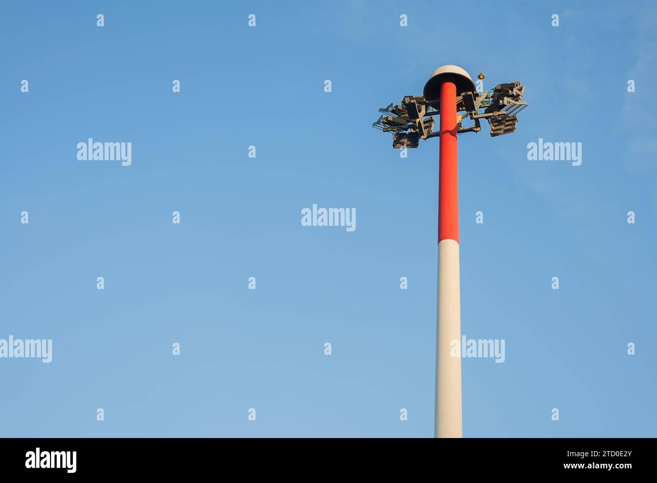 Tall floodlight pole with multiple lights on an airport tarmac, set ...