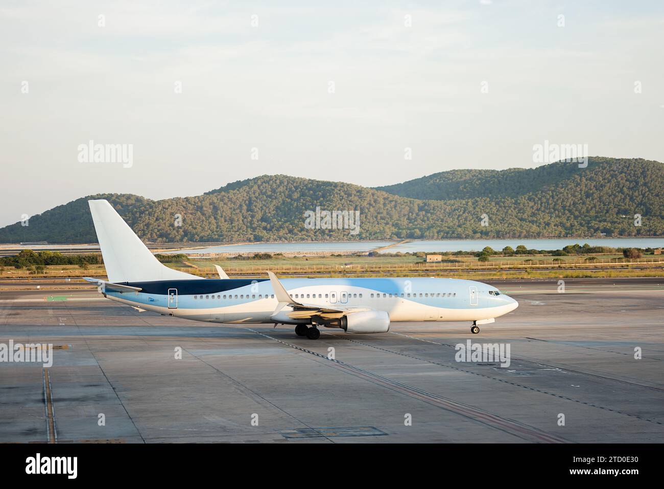 A commercial jet airplane parked on the tarmac at an airport with a ...