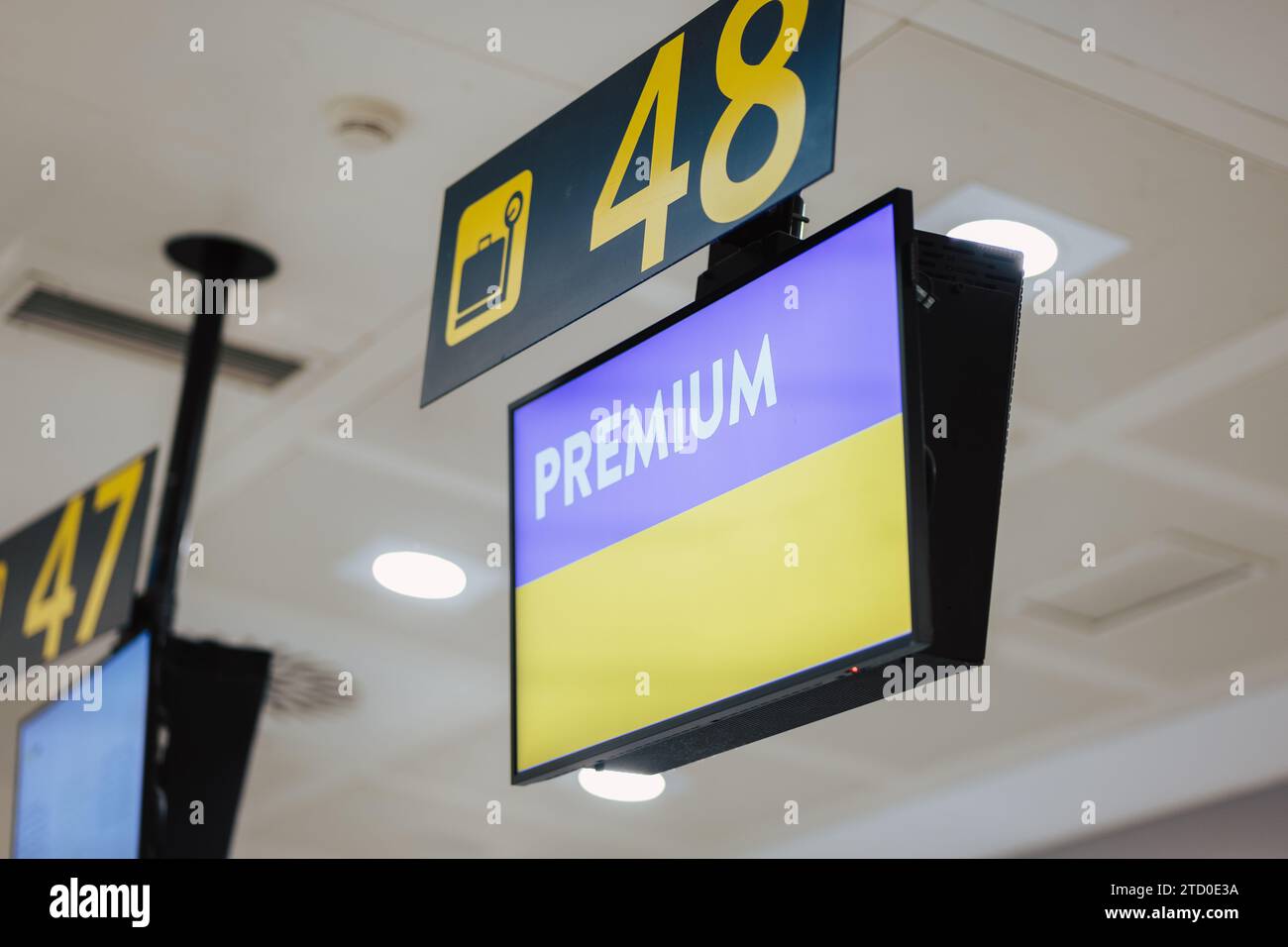 Illuminated 'Premium' check-in sign hanging at an airport counter for ...